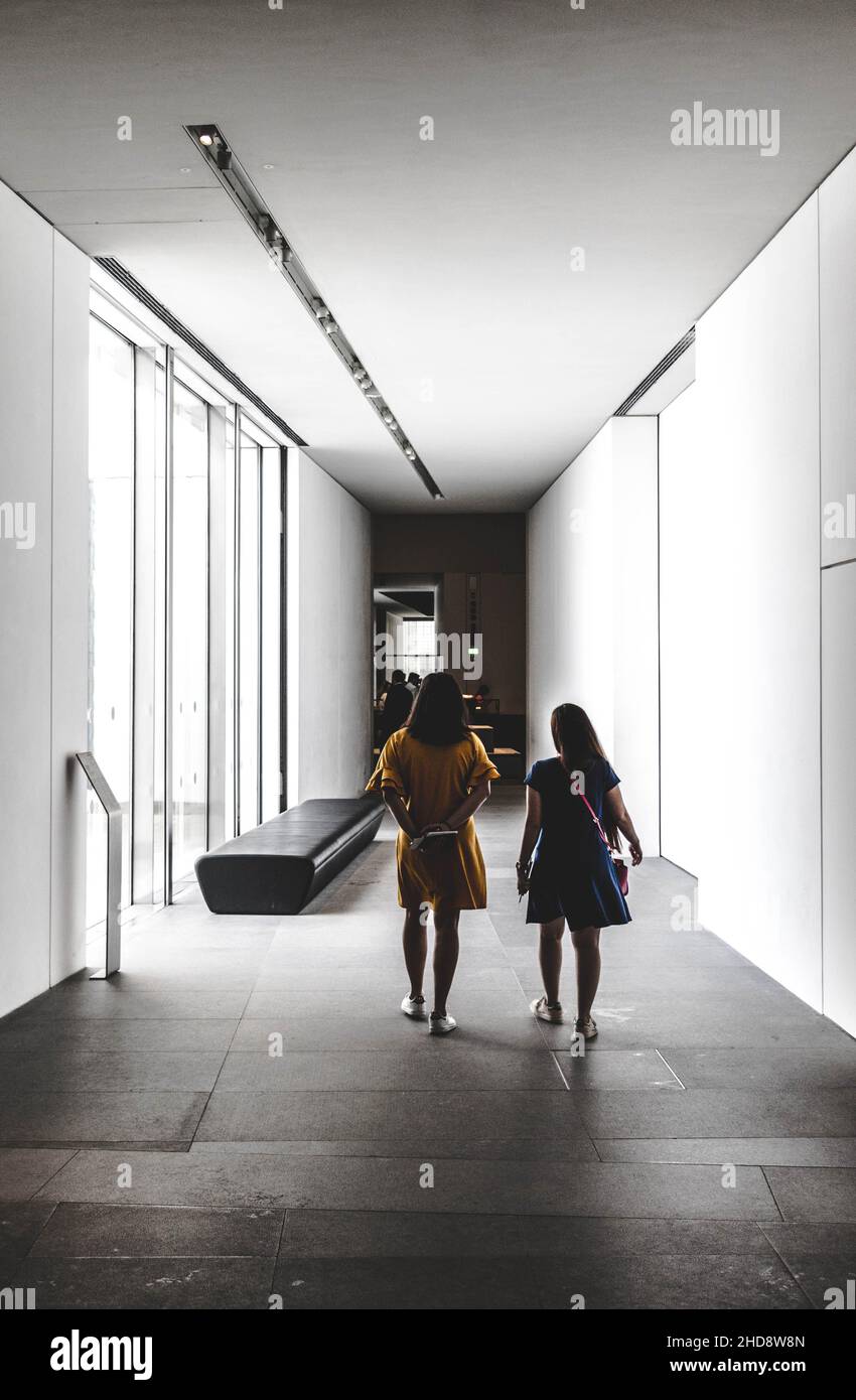 Young women walking through the hallway of a minimalistic building with ...