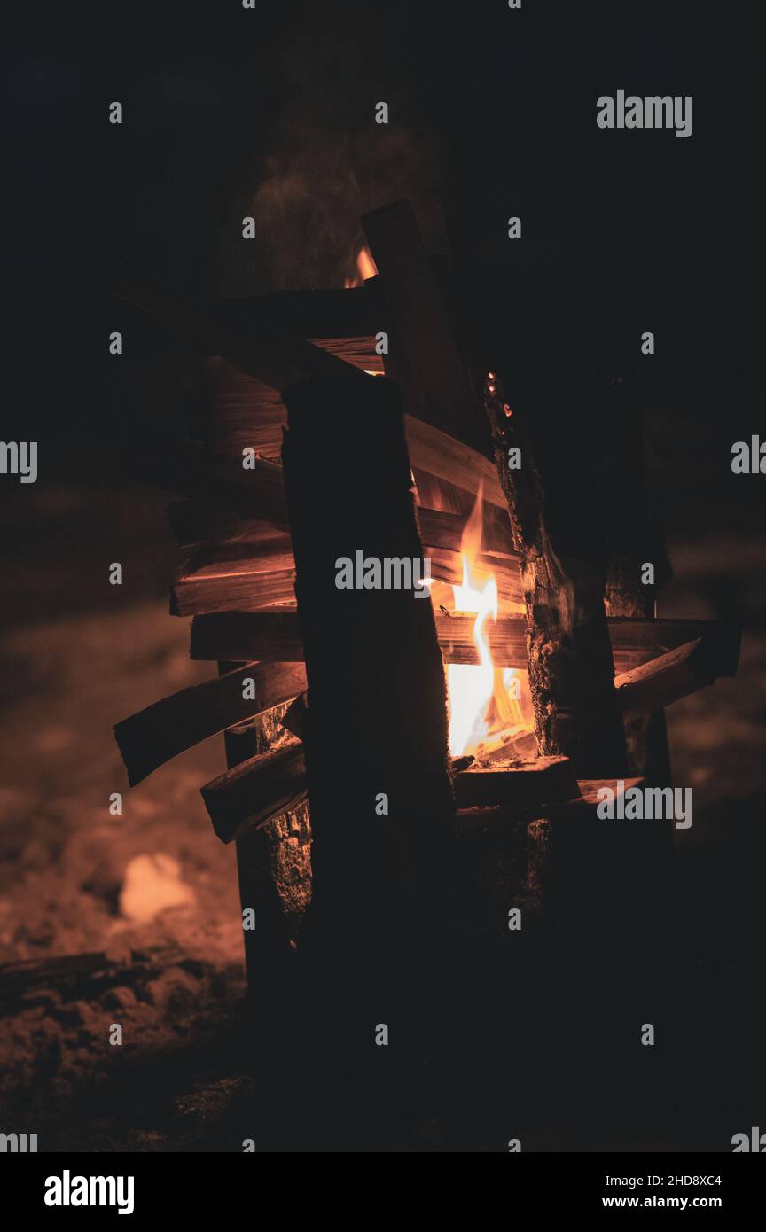 smoke from the flames of the fire and a wooden pole burning vertically ...