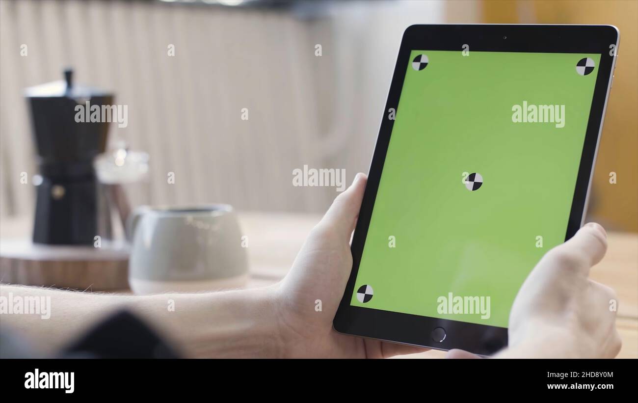 Close up of young man hands holding black tablet with green screen and ... Close up of young man hands holding black tablet with green screen and ...
