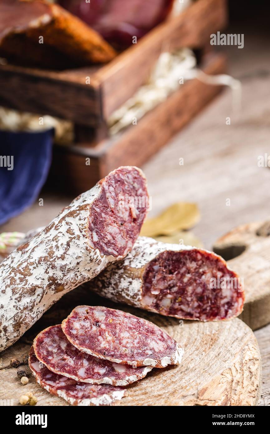 Smoked sliced salami on a old wooden table. Sausages with edible mold ...