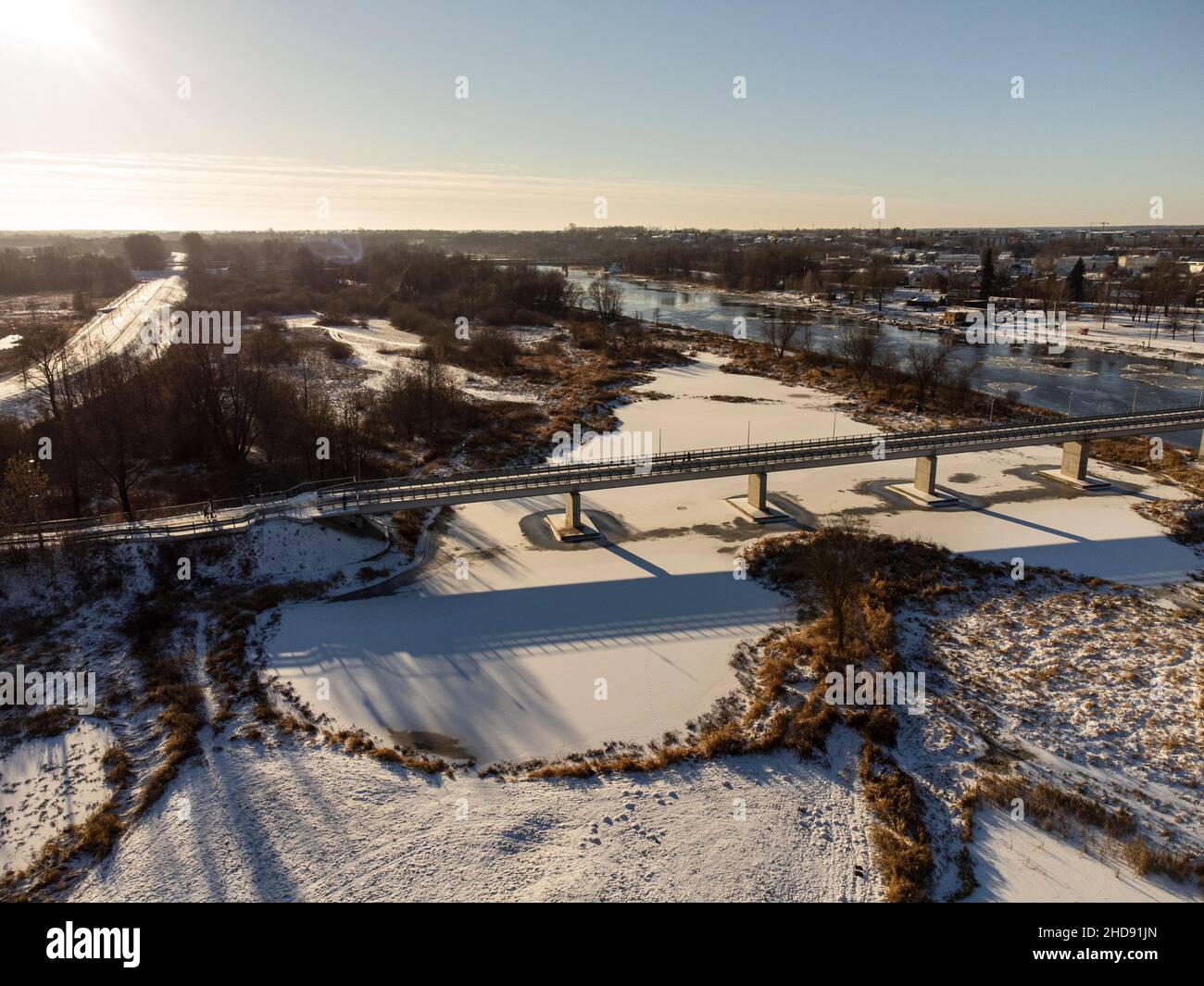 City, river and bridge on a sunny winter snowy day seen and ...