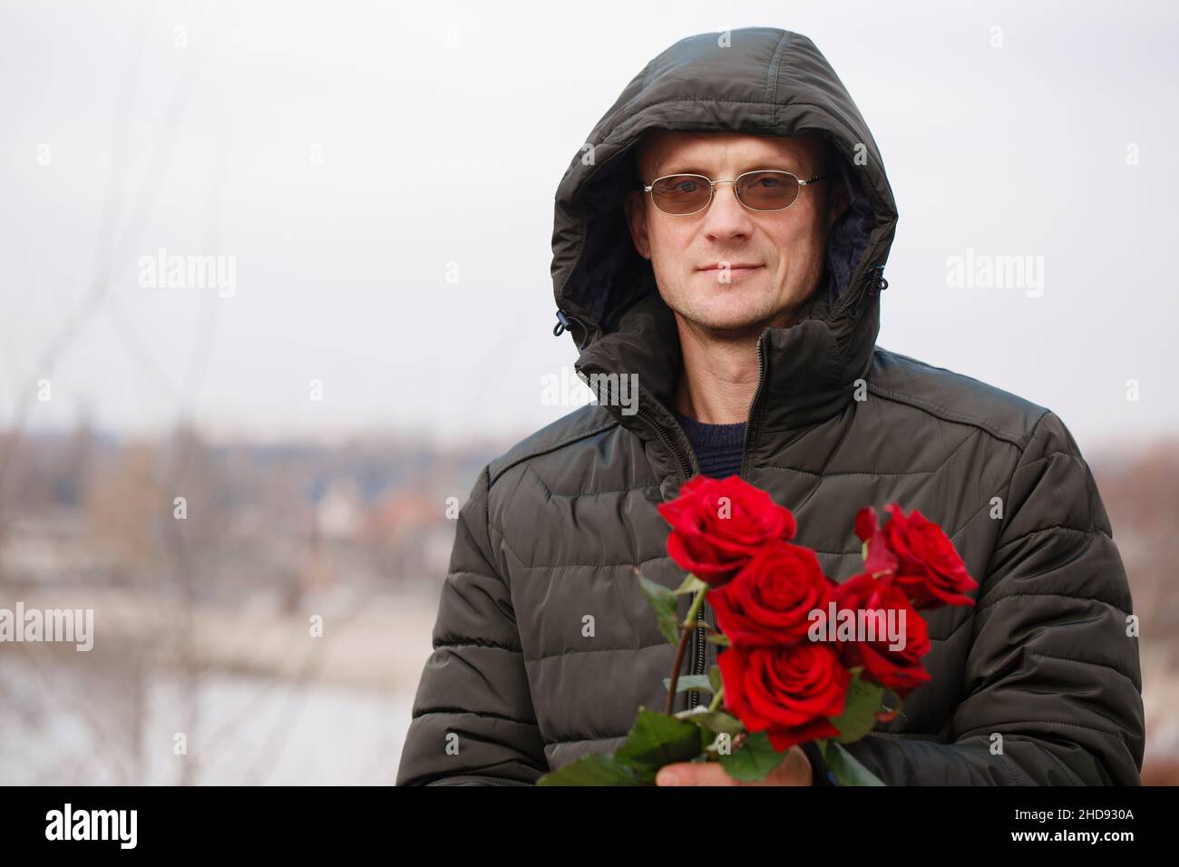 Adult man with bouquet of red roses on the street Stock Photo - Alamy