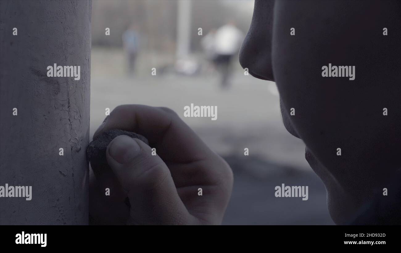 Baby scratch iron pillar using a stone - anger concept. Close up of ...