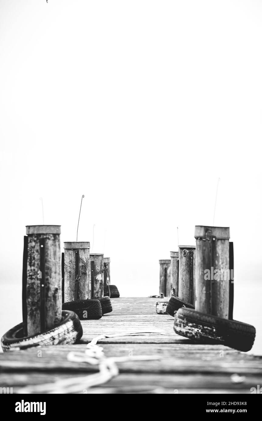 Vertical shot of a wooden beach dock with rubber wheels on a white ...