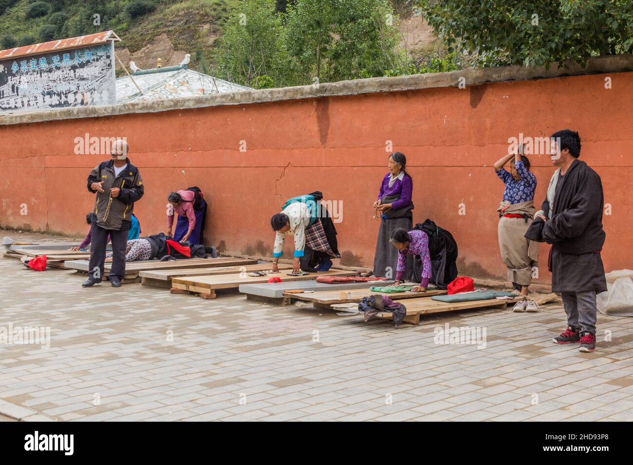 XIAHE, CHINA - AUGUST 25, 2018: Tibetan Buddhist devotees pray in front ...