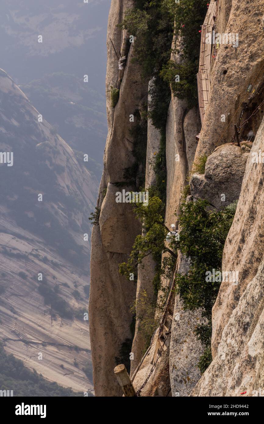 Narrow walkway at a sheer cliff at the South Peak of Hua Shan mountain ...
