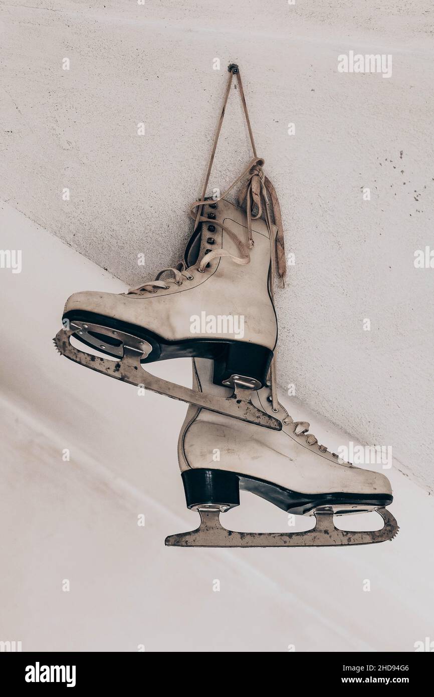 Pair of vintage white leather ice skates hanging from the wall Stock ...