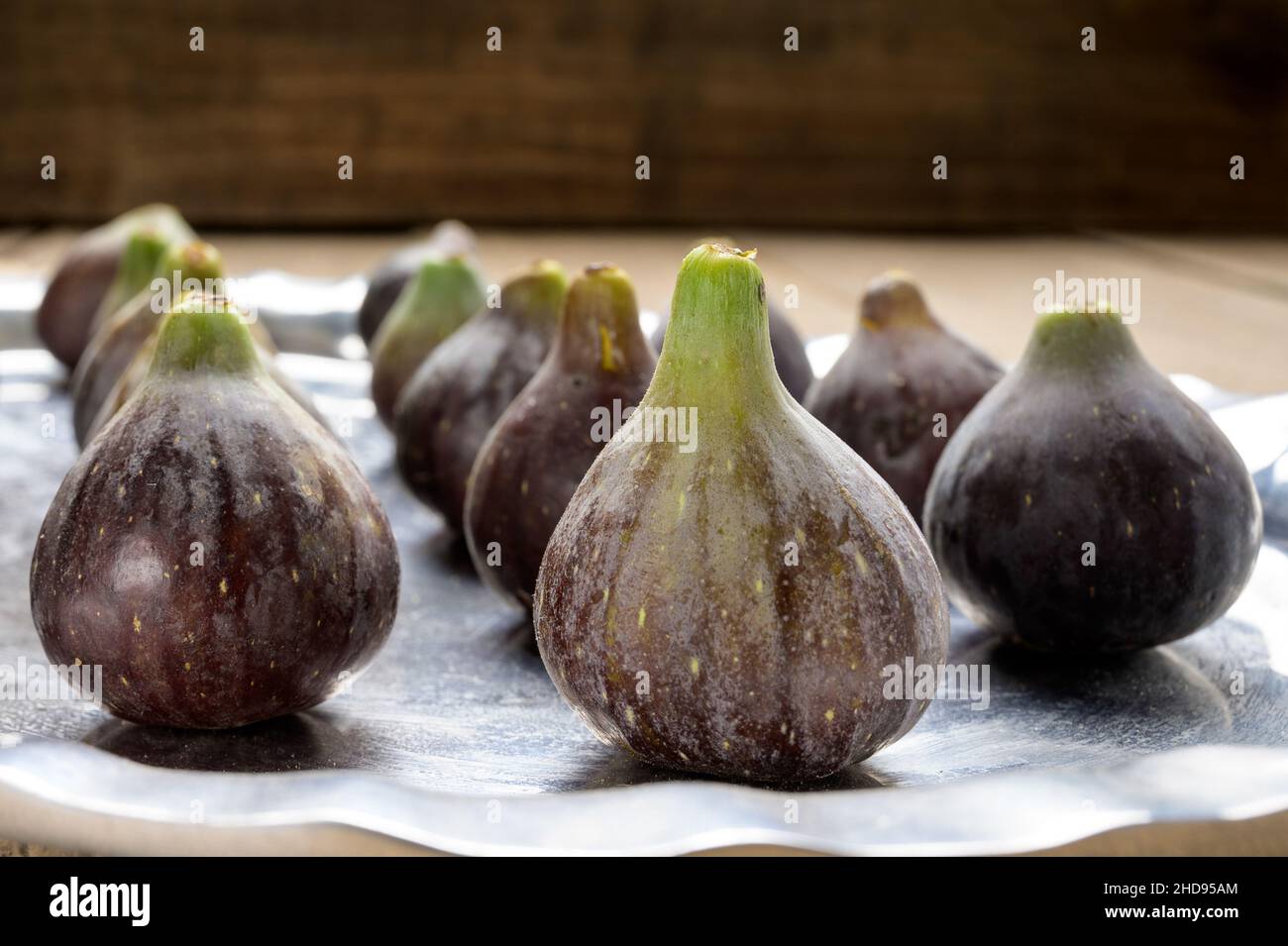 Figs on a silver platter in the wood background in a dark setting Stock ...
