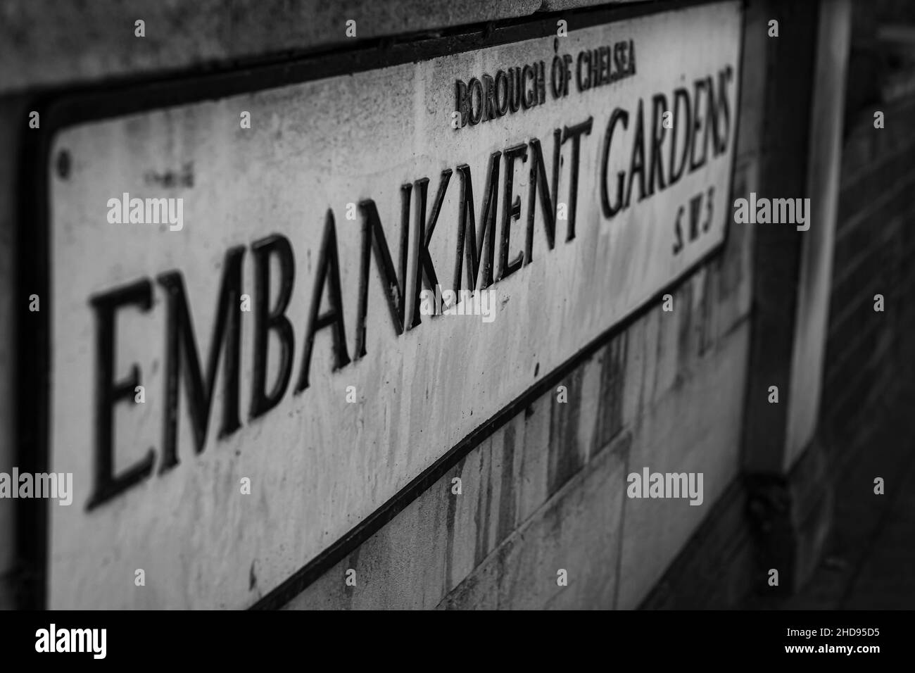 Grayscale shot of the Embankment gardens sign on the building wall ...