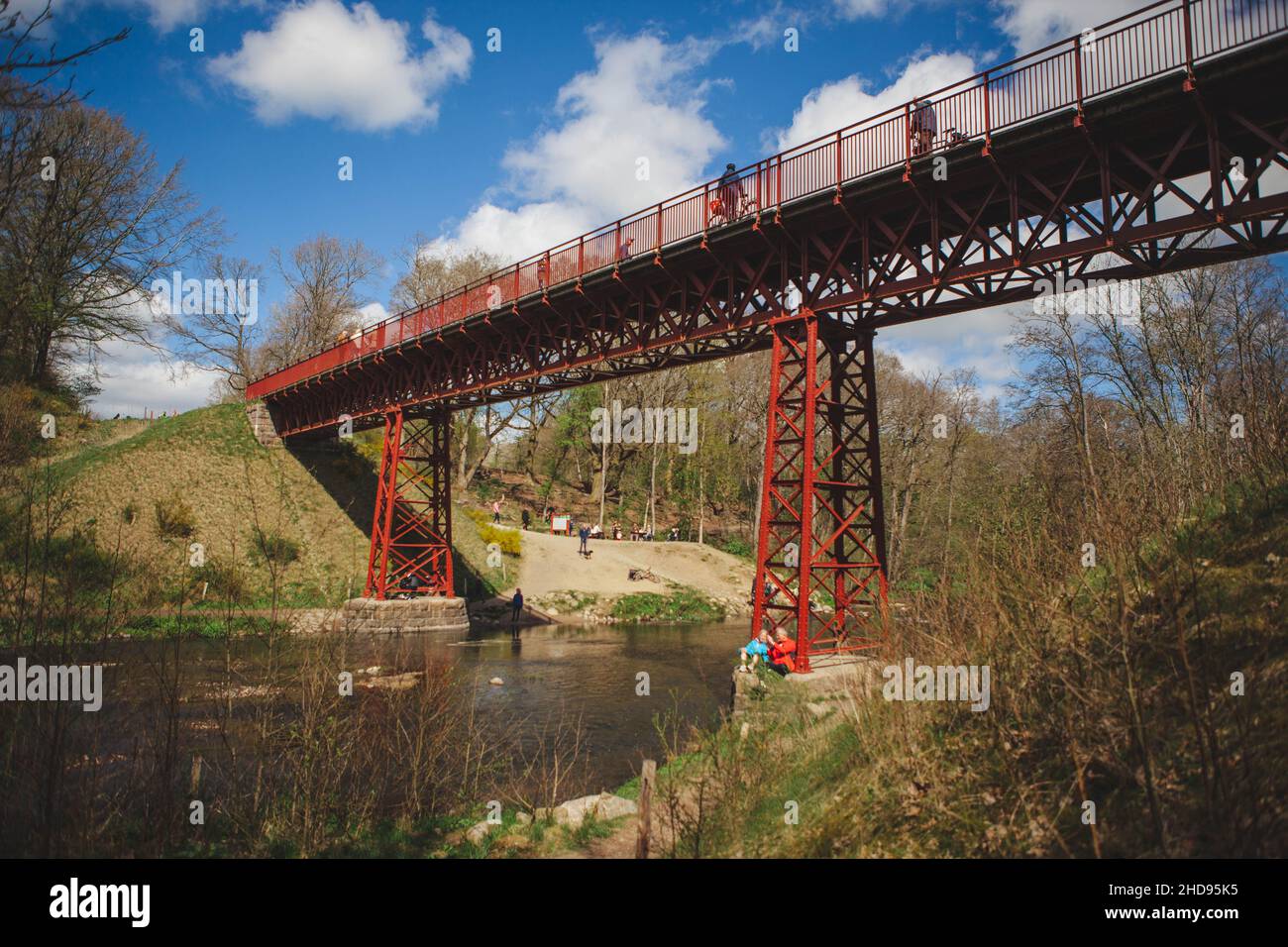 View of a red railway bridge above the river Stock Photo - Alamy