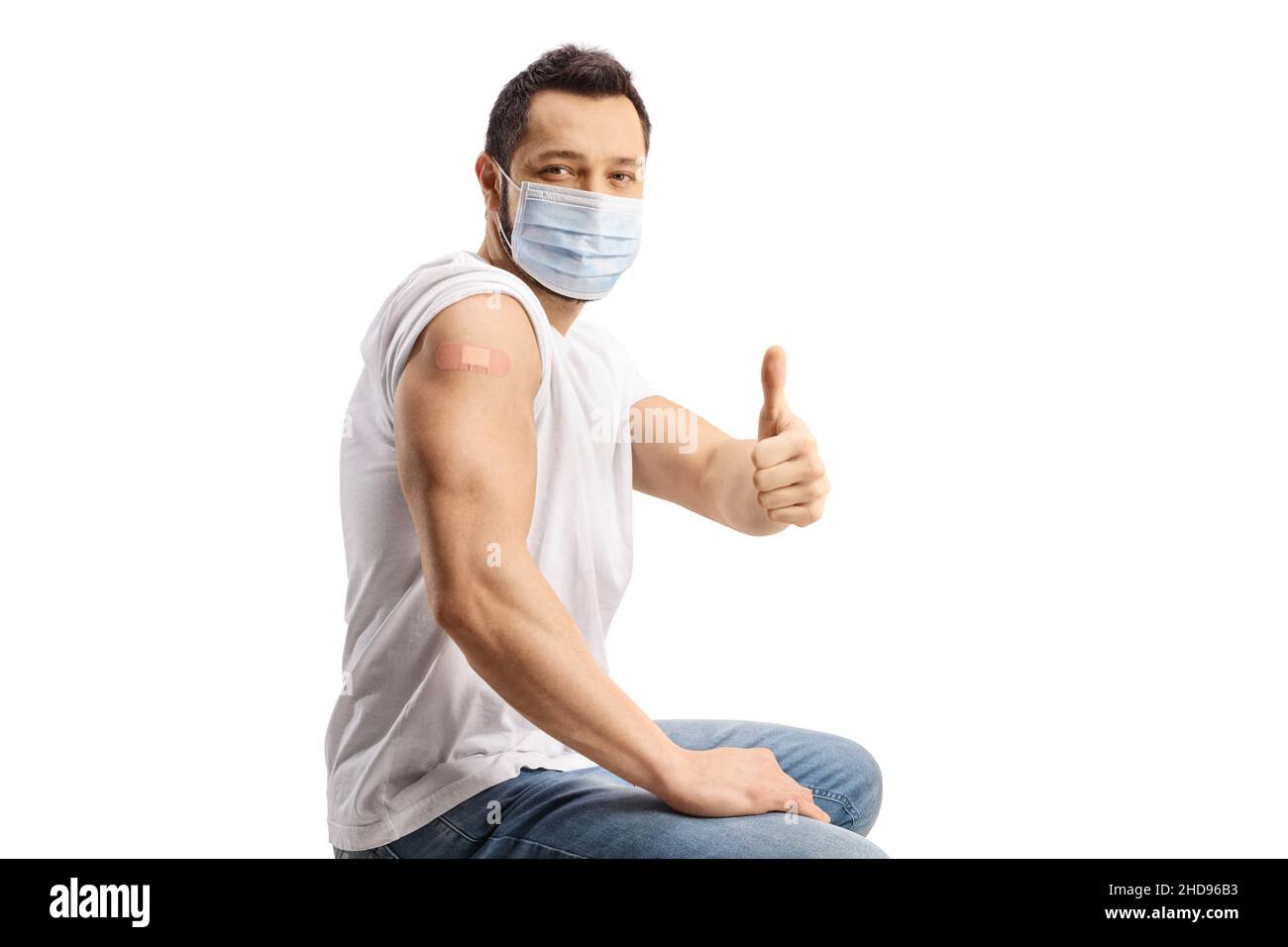 Young man with a mask showing his arm with a vaccine patch and ...