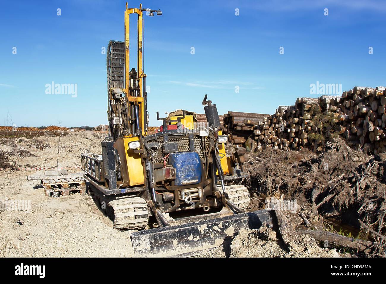 Mini-drilling rig on crawler track on site of sawn forest where large ...