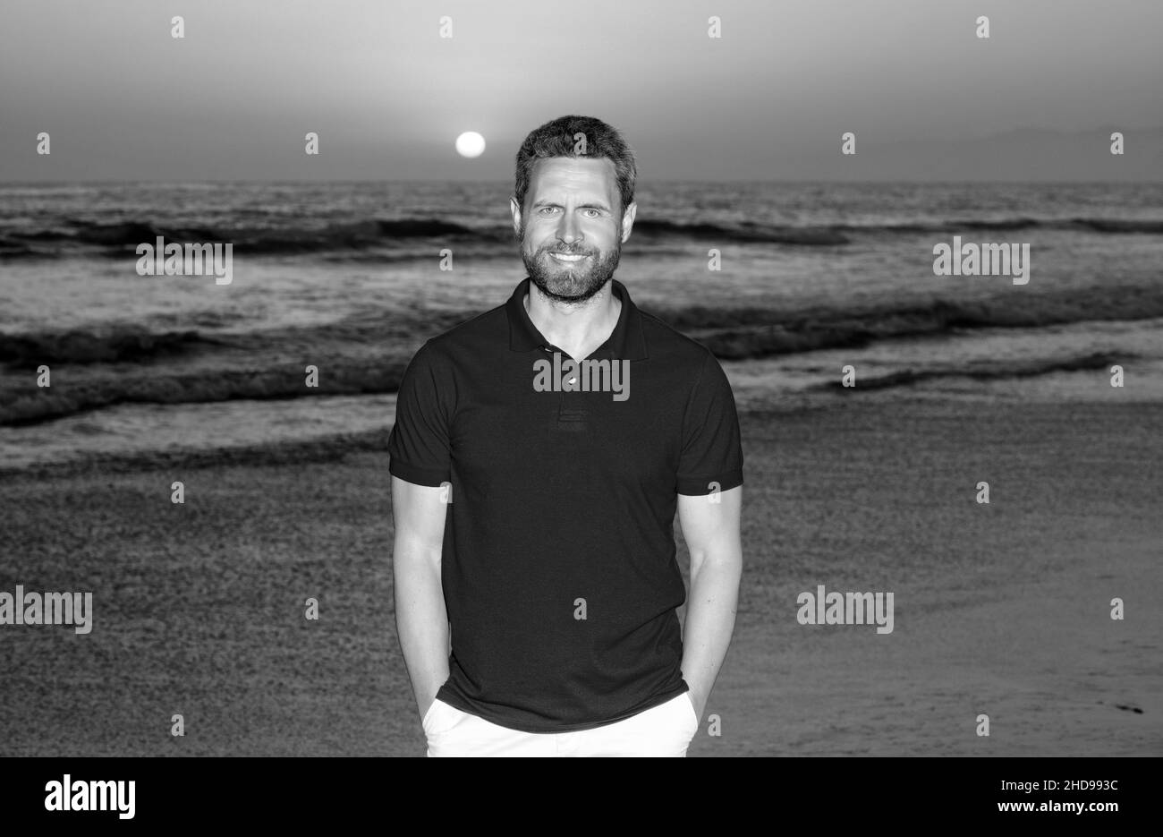 happy bearded handsome man in summer shirt on beach with sunset over ...