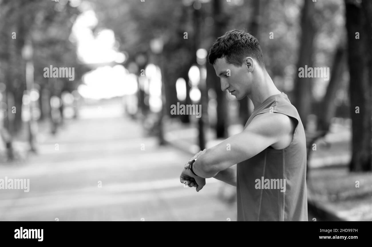 Sportsman check time on wristlet watch during outdoor athletic training ...