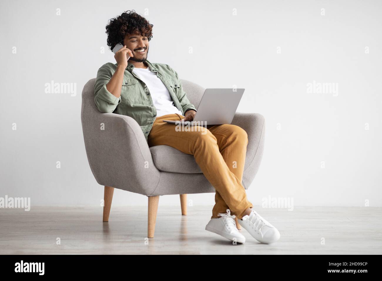 Handsome indian guy working online, having phone conversation Stock ...