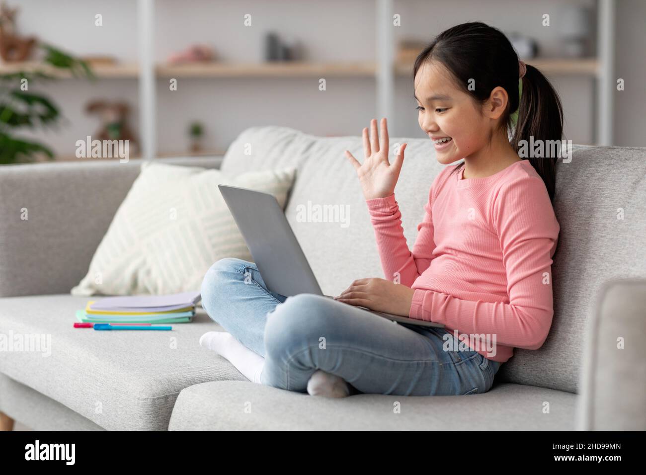 Adorable asian child having video call with friend Stock Photo - Alamy