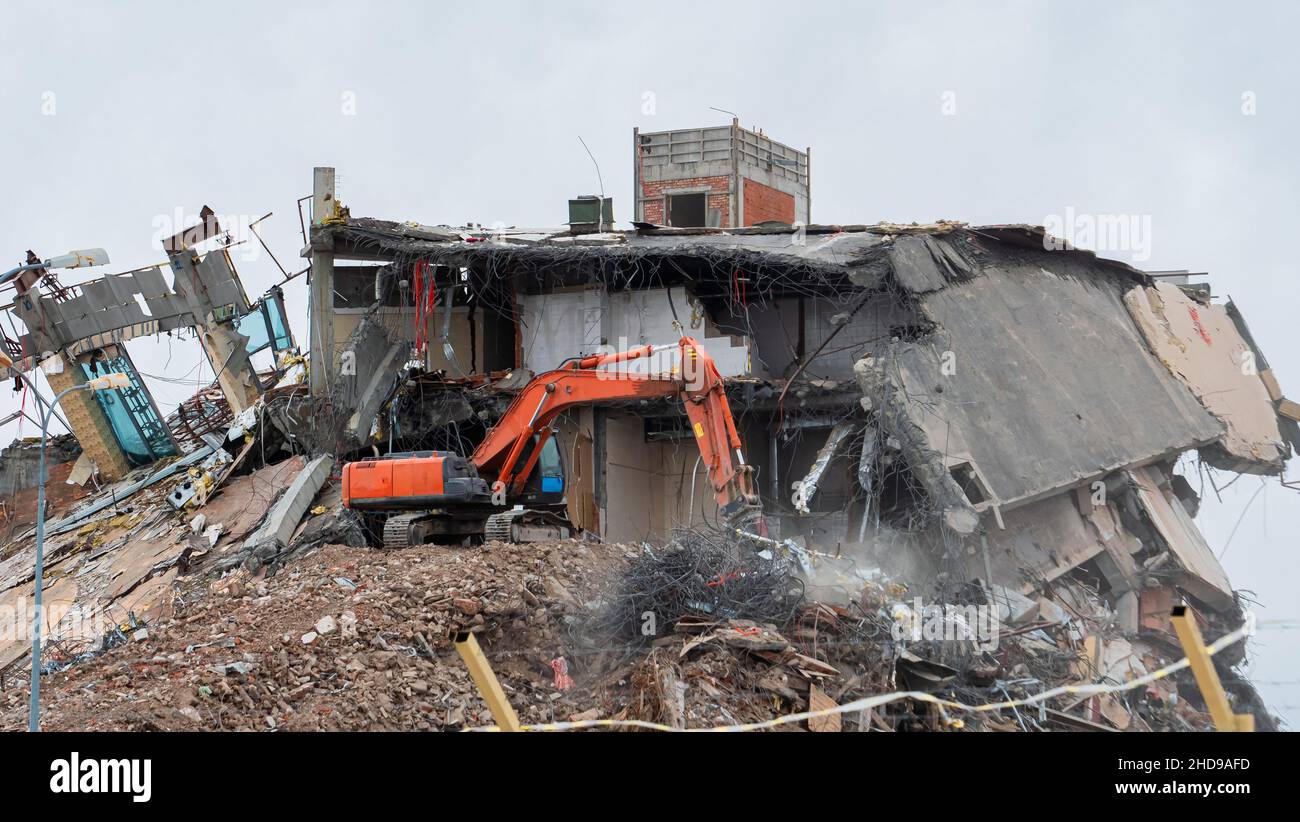 Heavy equipment being used to tear tearing down building construction ...