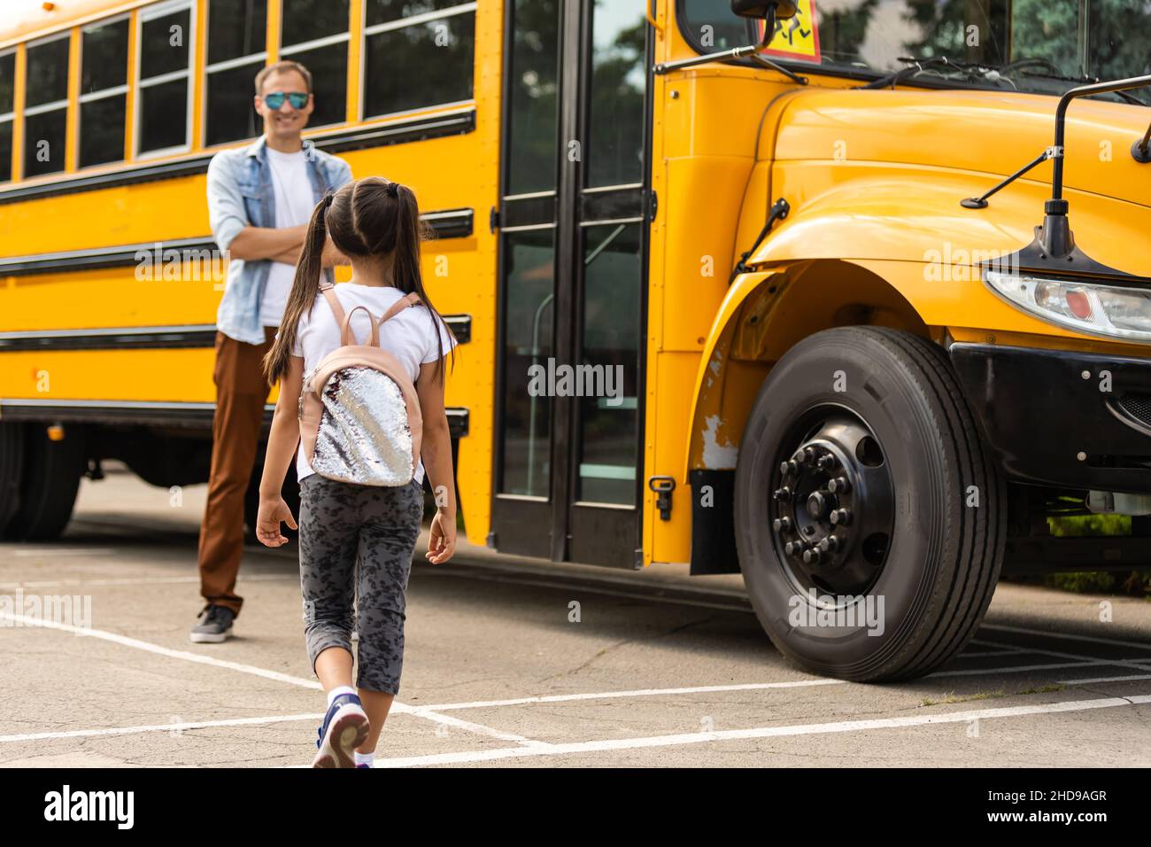 school bus driver is standing in front of his bus Stock Photo - Alamy