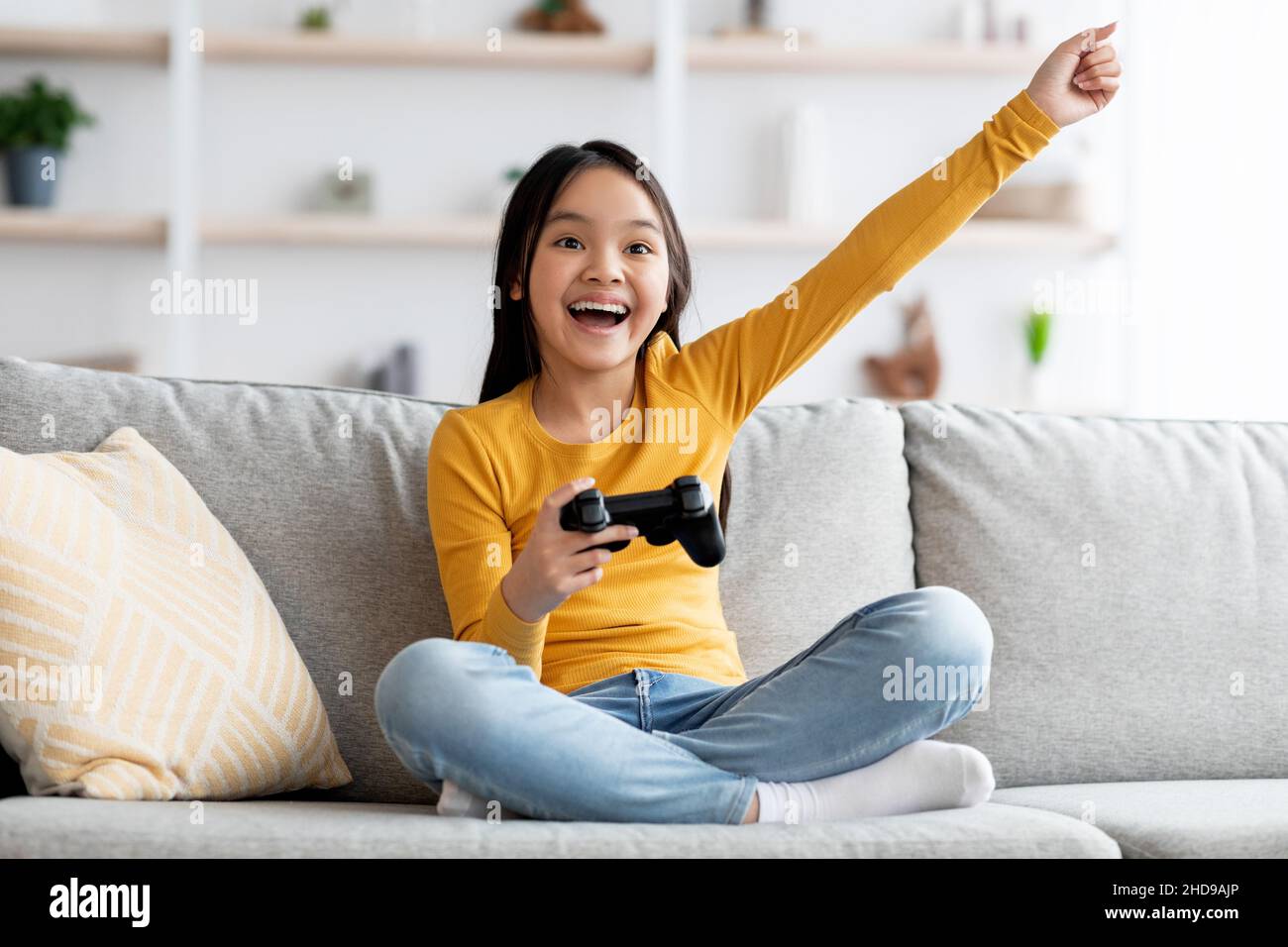 Happy asian girl playing handheld video game at home Stock Photo - Alamy