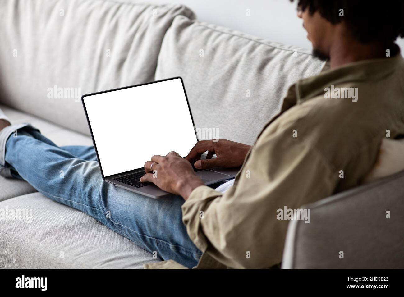 Black Man Using Laptop Computer With Blank Screen While Sitting On ...
