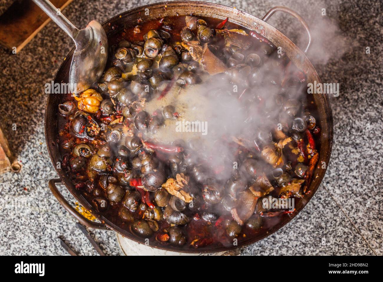 Cooking snail in a pan in a restaurant in Furong Zhen town, Hunan ...