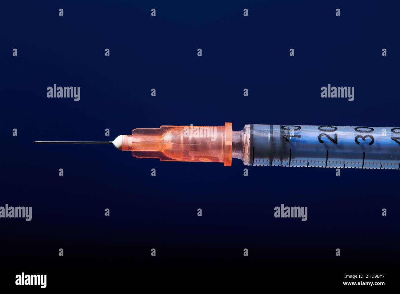 Closeup of a horizontally placed syringe with needle having a dark blue ...