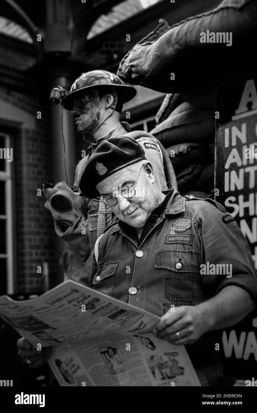 Mono close up of wartime, 1940 ARP warden (air raid precaution) reading ...