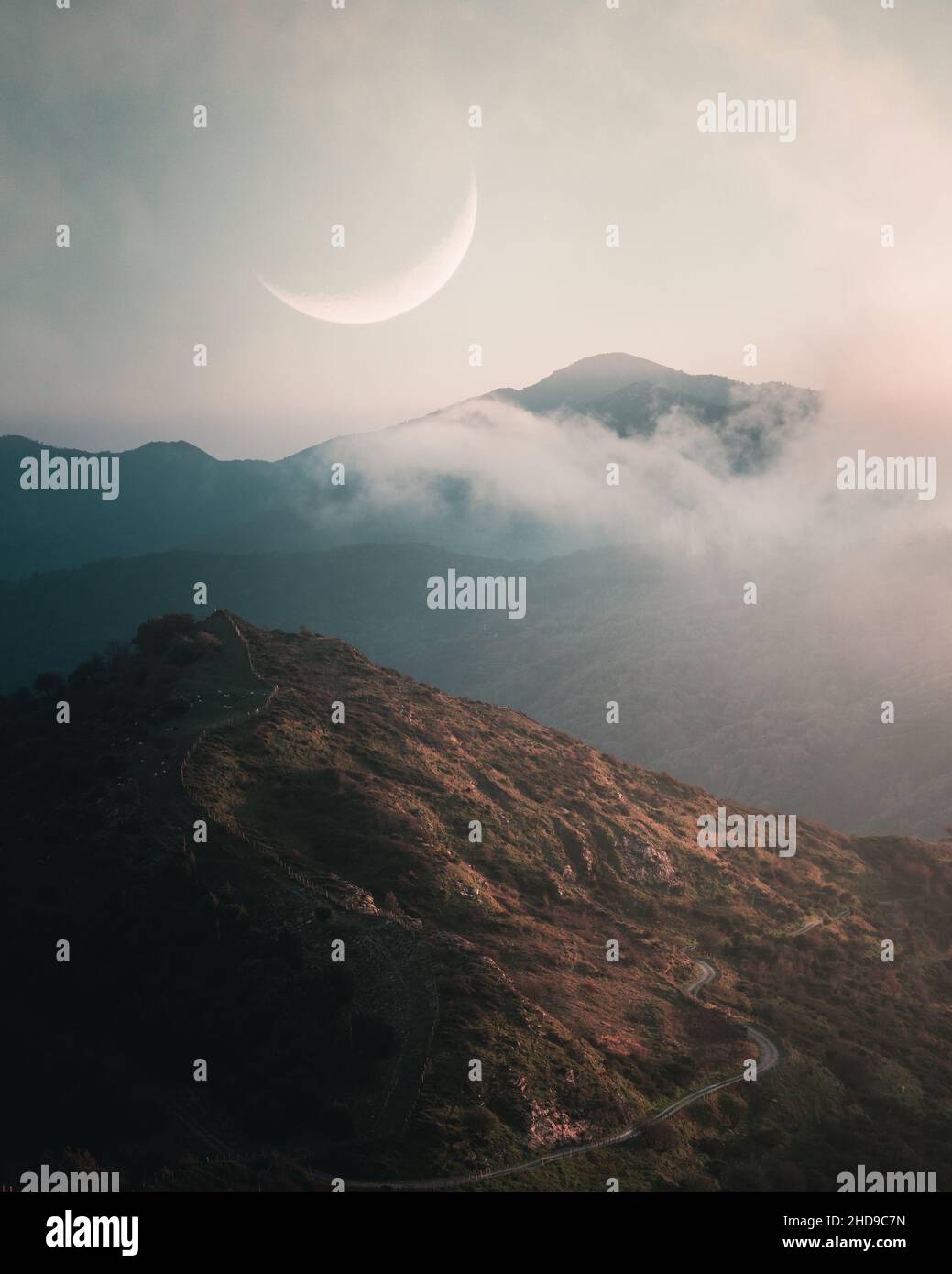 Crescent moon over a mountain range in Sicily, Italy on a foggy day ...