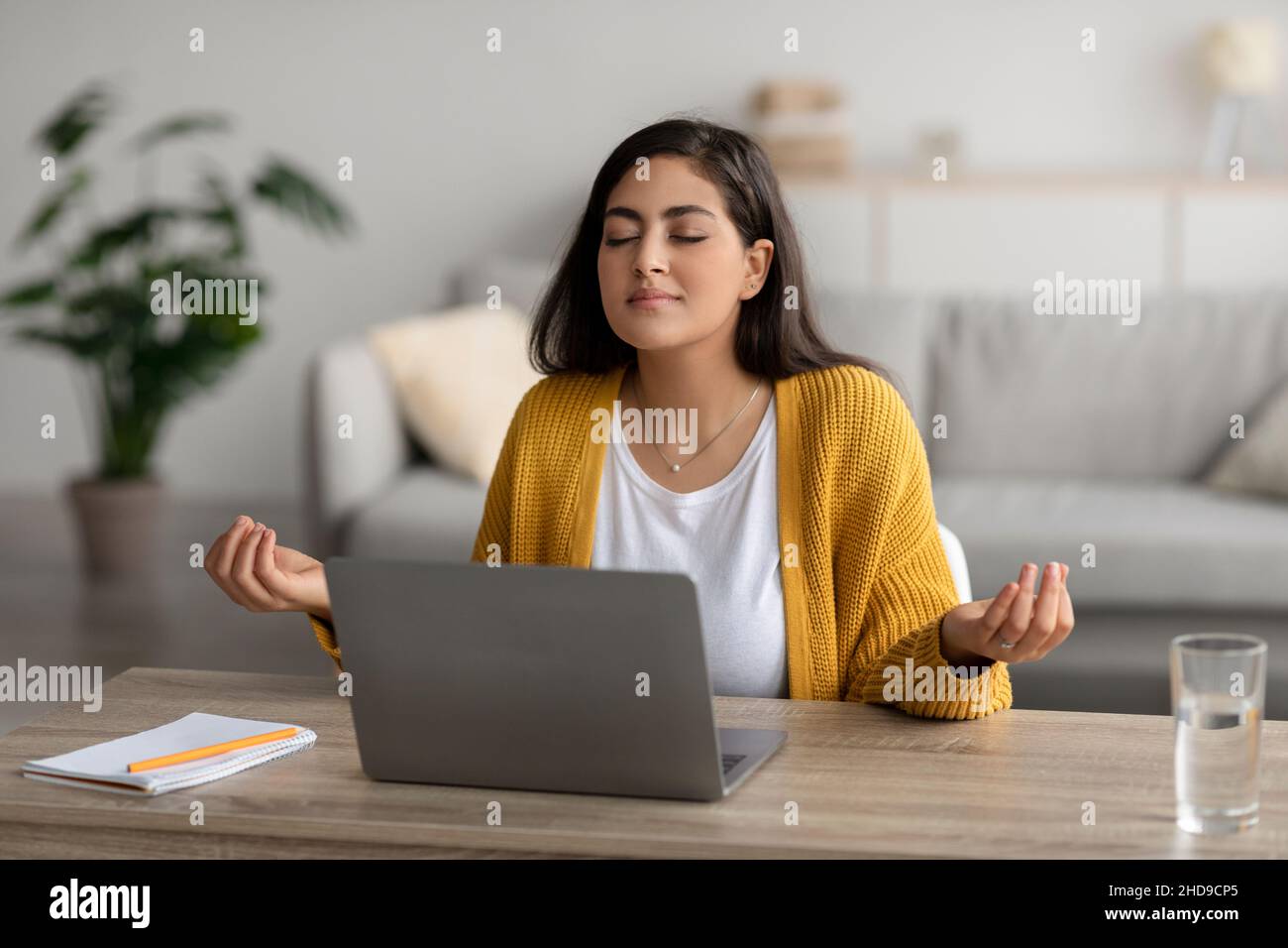 Workplace stress management. Calm arab woman meditating with closed ...
