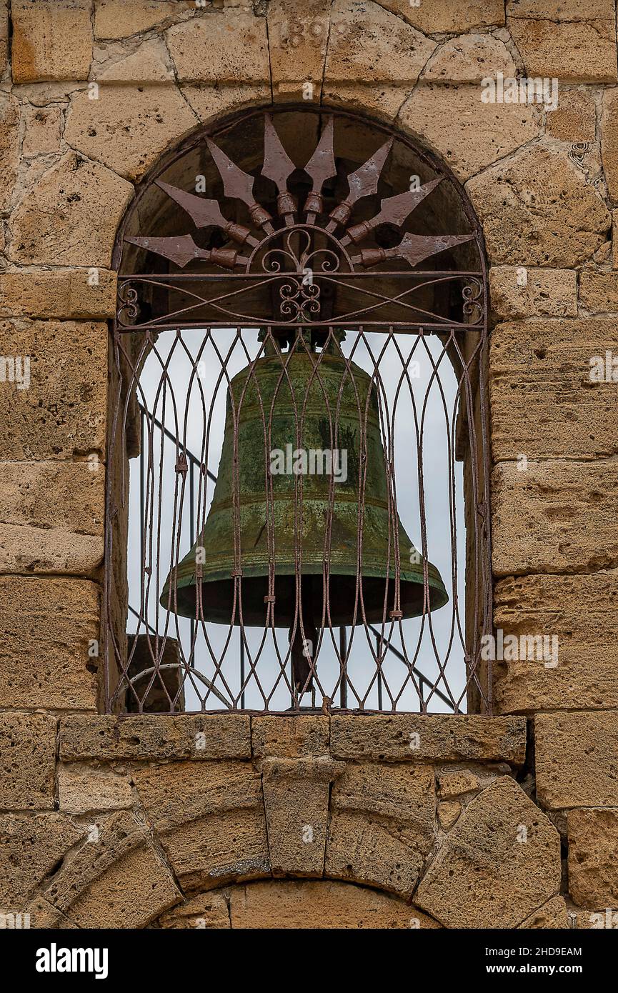 old antique brass or bronze bell housed in a stone bell tower on the ...
