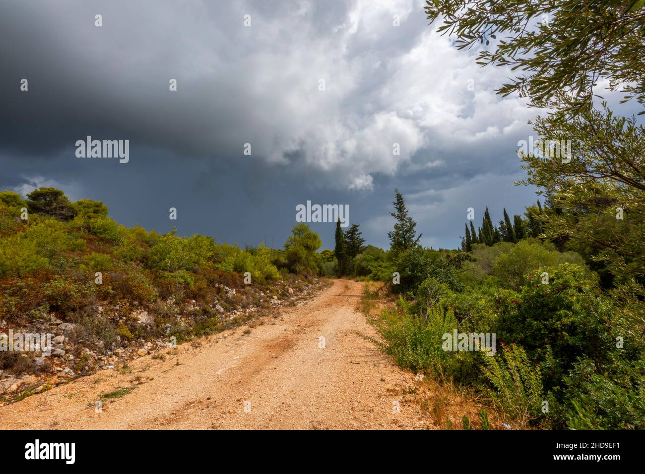 stormy skies and thunder clouds gathering over a remote contry lane in ...