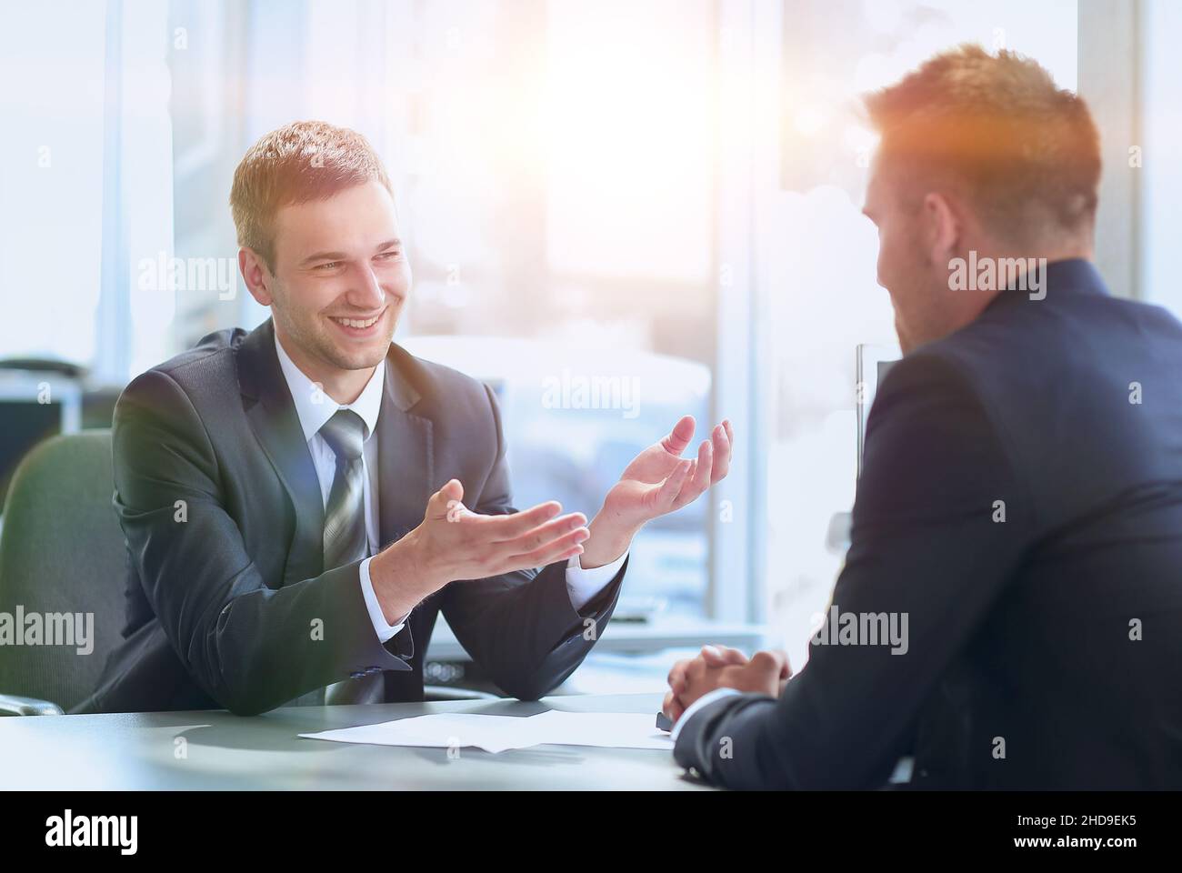 business partners talking while sitting at your Desk Stock Photo - Alamy