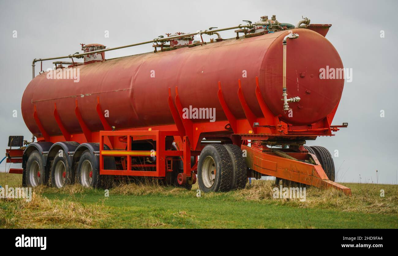 an old red lorry tanker trailer converted to a farmer's water container ...