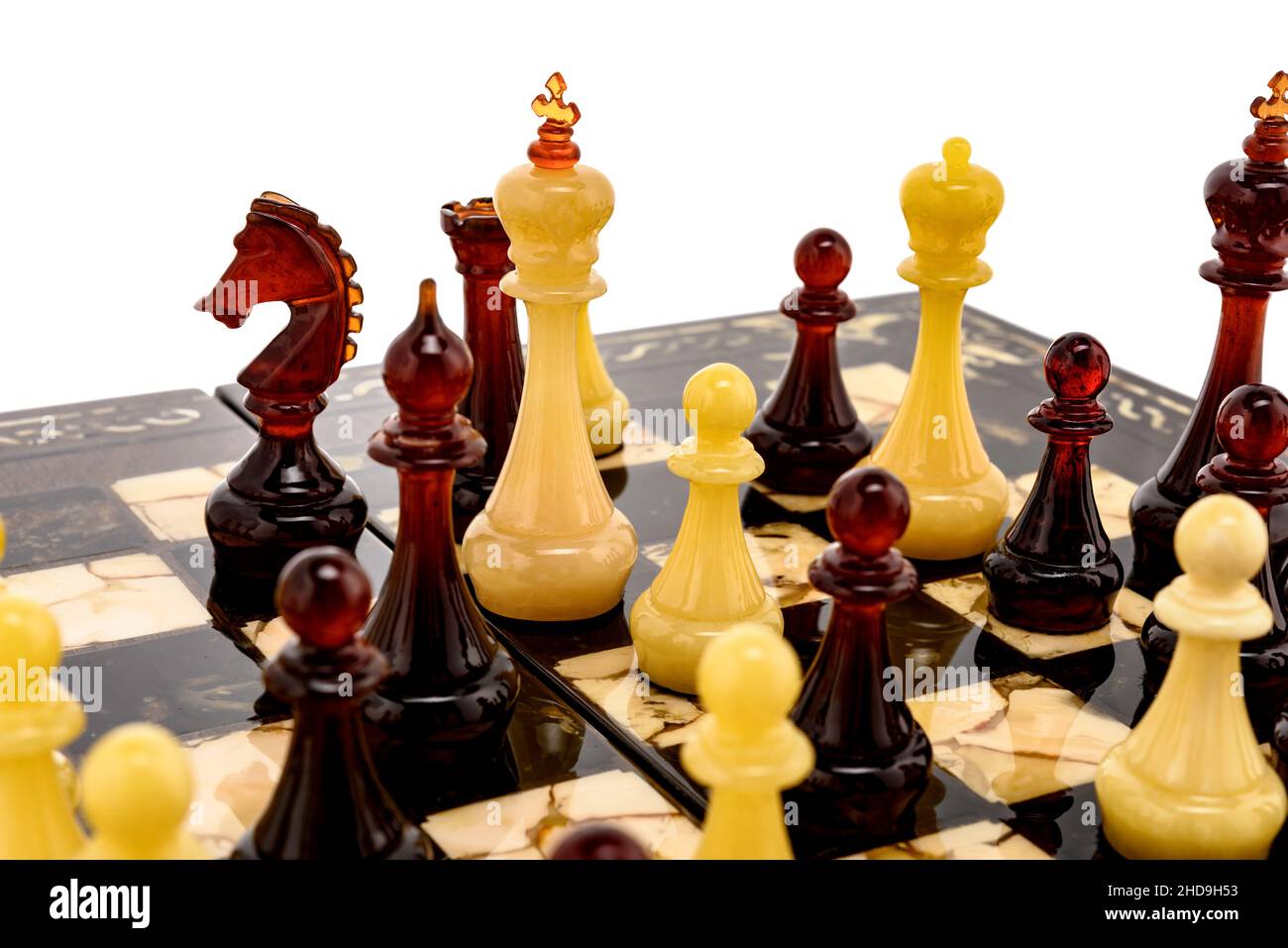 Natural amber different chess pieces figures standing on pearl board in ...