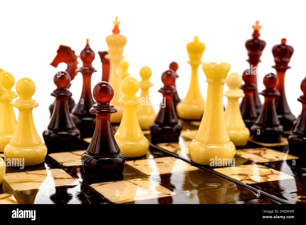 Natural amber different chess pieces figures standing on pearl board in ...