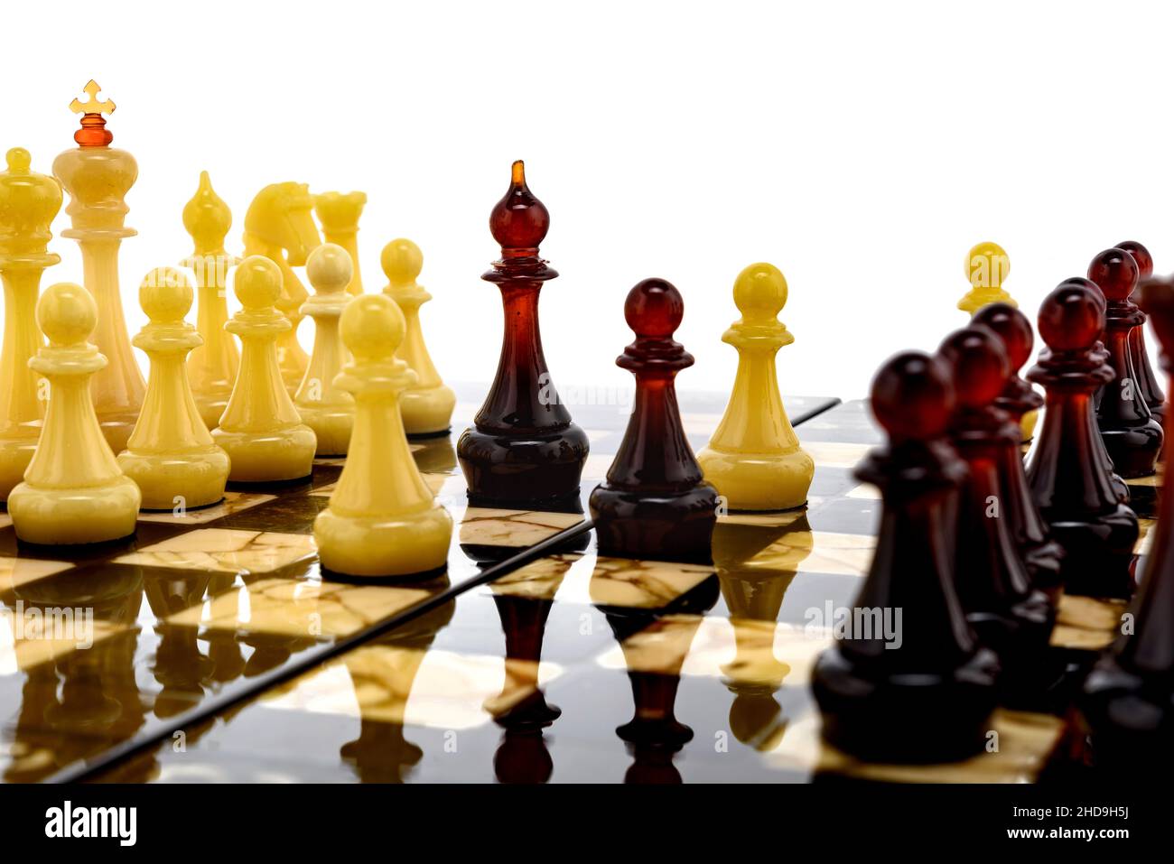 Natural amber different chess pieces figures standing on pearl board in ...