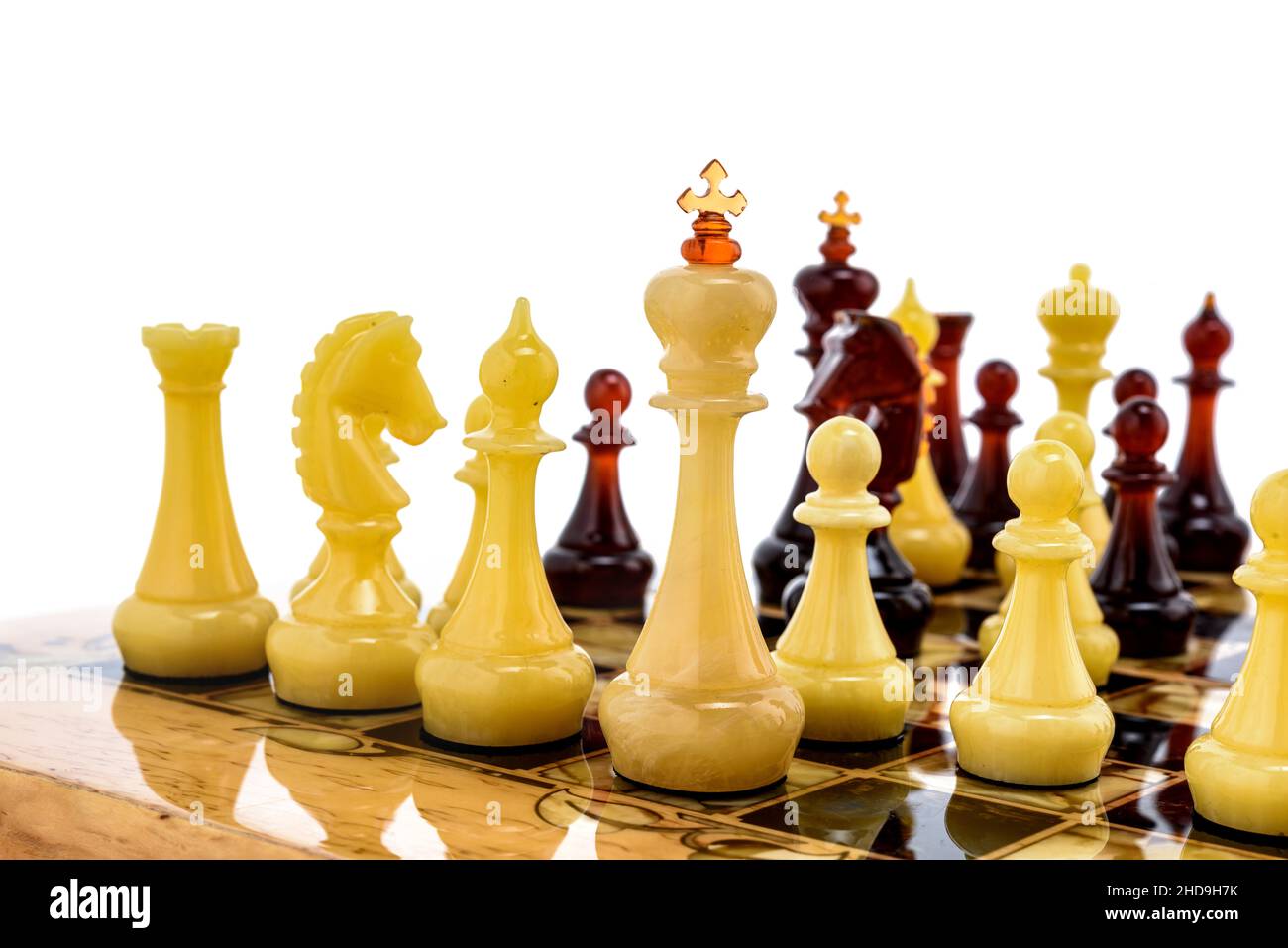 Natural amber different chess pieces figures standing on pearl board in ...