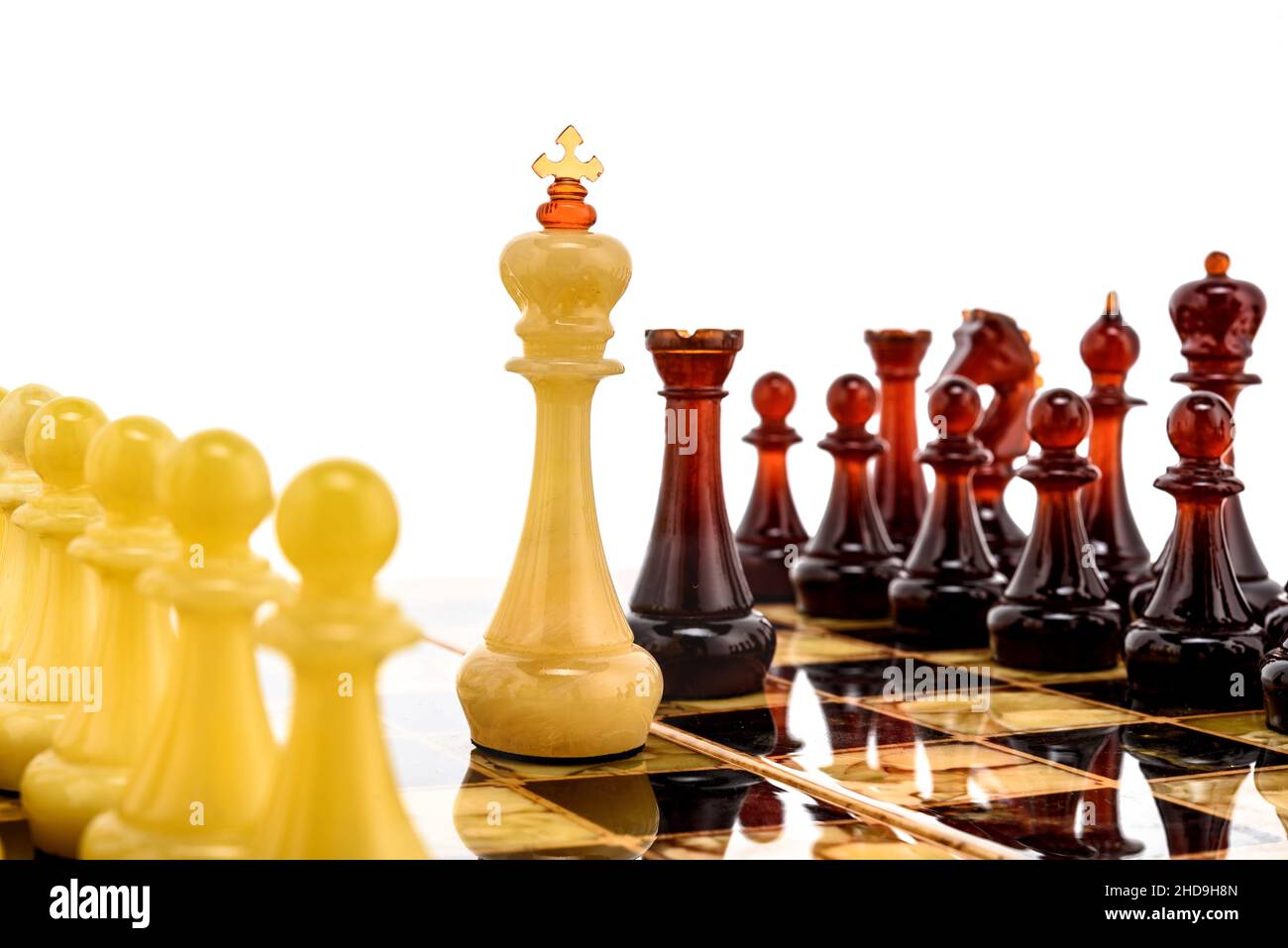 Natural amber different chess pieces figures standing on pearl board in ...