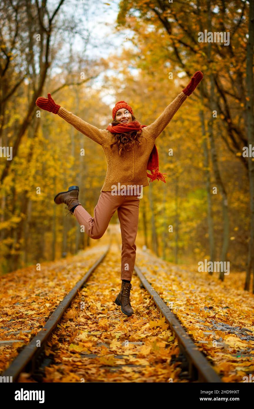 Woman jumping over railroad in autumn forest Stock Photo - Alamy