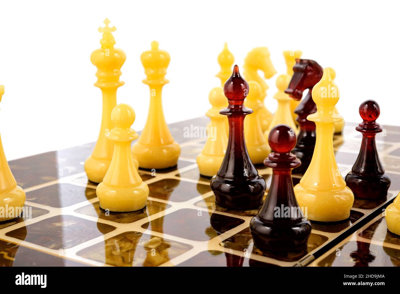 Natural amber different chess pieces figures standing on pearl board in ...