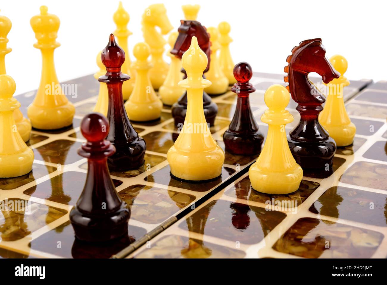 Natural amber different chess pieces figures standing on pearl board in ...