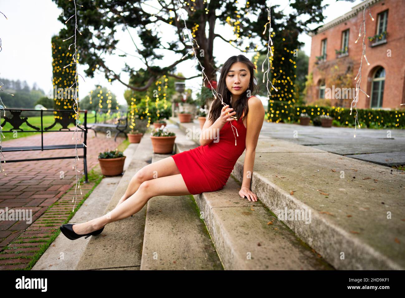 Young East Asian Woman in Red Party/Holiday Dress Lounging on Steps ...