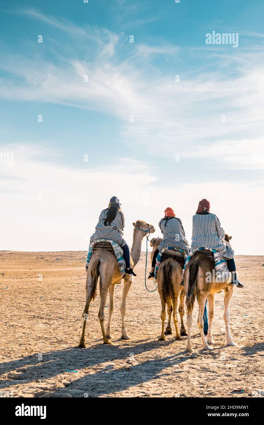 Three people riding camels in a desert hi-res stock photography and ...