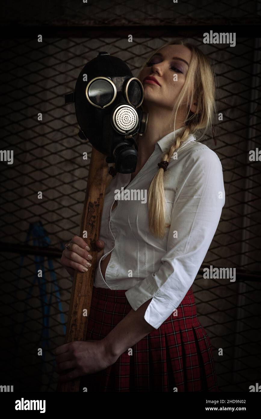 Woman with toxic protective mask holding axe in an underground ...