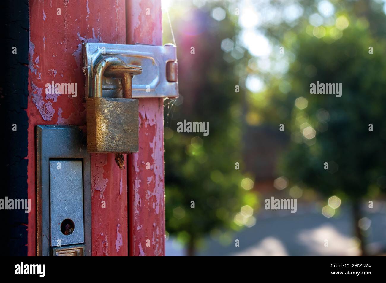 The red metal door locked Stock Photo - Alamy