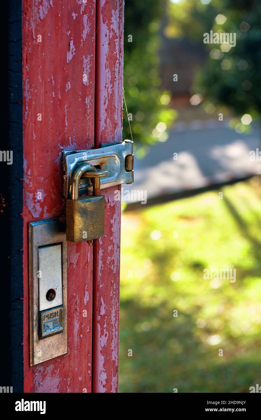 The red metal door locked Stock Photo - Alamy