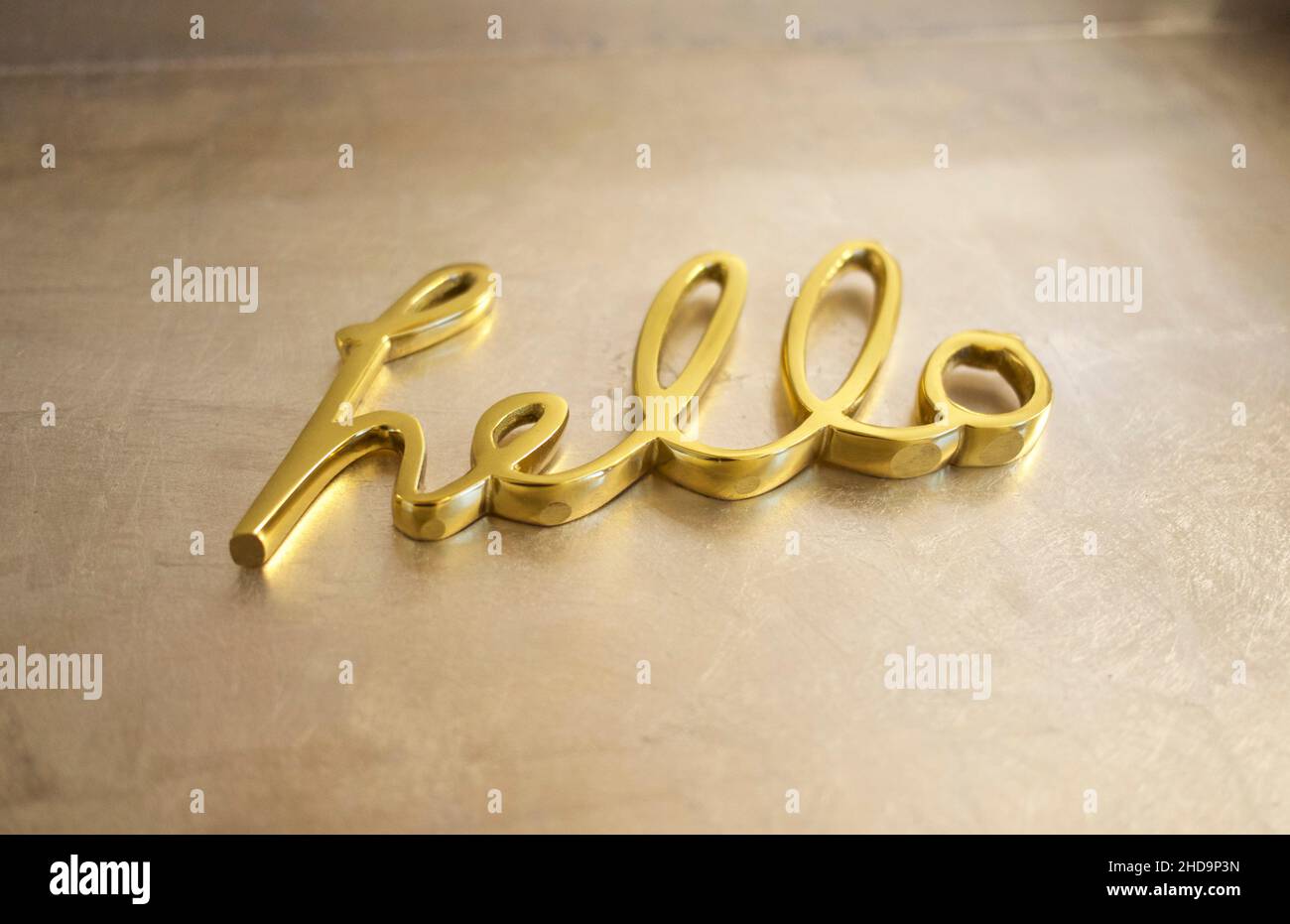 Gold hello sign on a metal plate Stock Photo - Alamy
