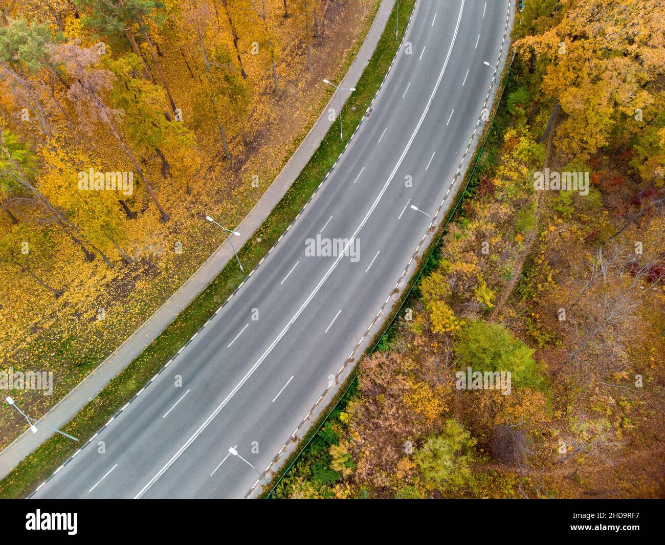 Look down on driveway street curve in autumn city park. Aerial on ...