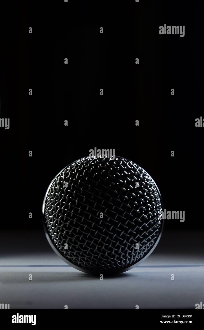 Close up shot of a microphone head on a white table with black ...