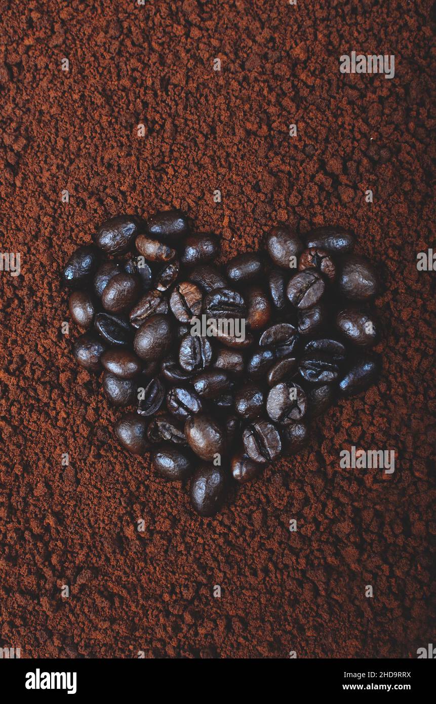 Heart shaped coffee beans over artificial instant coffee powder Stock ...